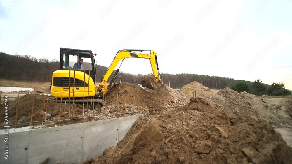 Slow motion of a digger digging a pit and throwing dirt. Close-up of a ...