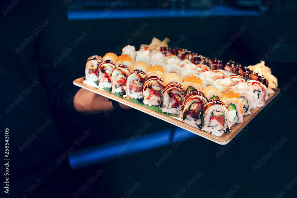 Close-up waiter holding Set of sushi red greed dragon, tuna Hokkaido ...