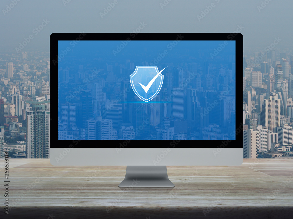 Security shield with check mark icon on desktop modern computer monitor ...