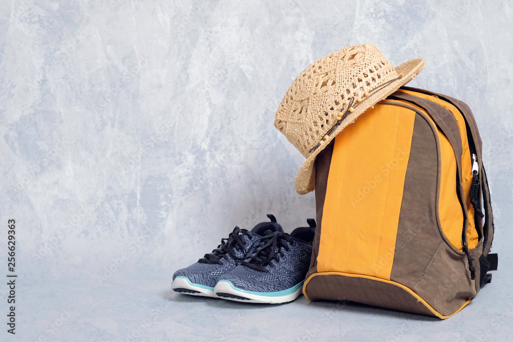 hiking backpack with footwear and straw hat on grey background, banner ...