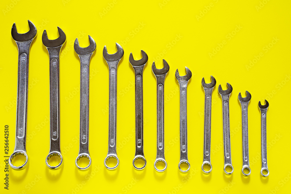 Spanner Set. Silver coloured spanners lying side by side in yellow ...