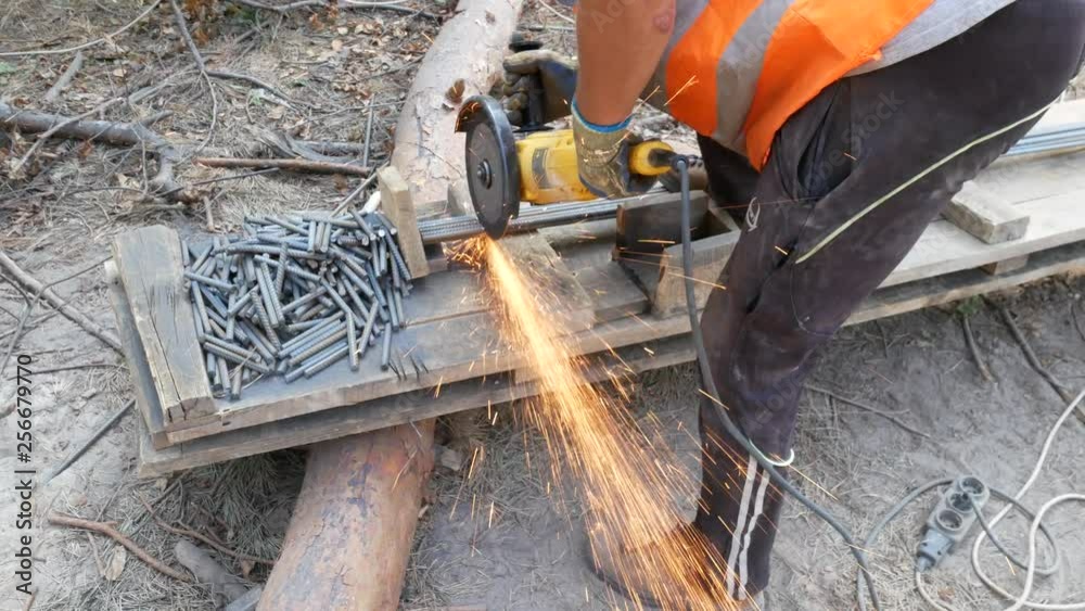 Cutting rebar round. The master holds in his hands a tool for cutting ...