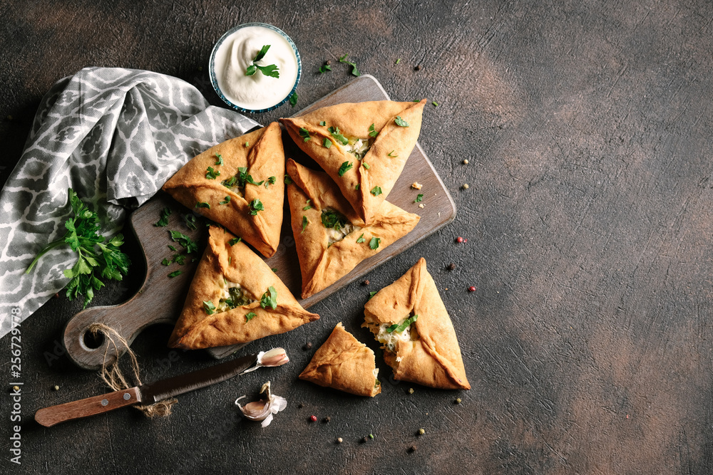 Meat or chicken triangular pies with sour cream, onions, garlic on a ...