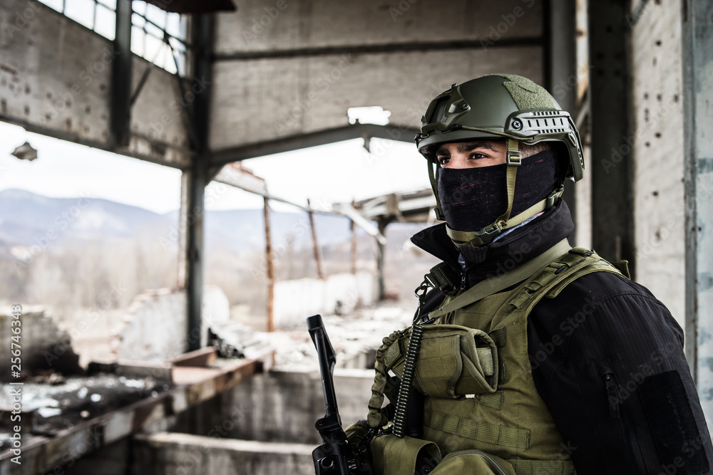 Foto de Special forces modern soldier standing in ruined building after ...