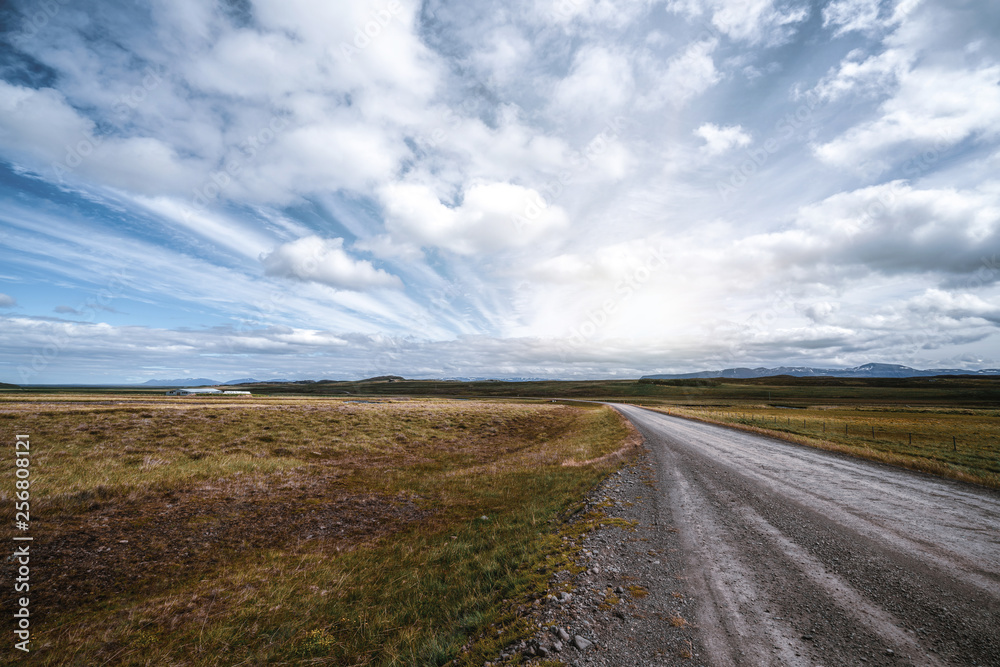 Empty gravel dirt road through countryside landscape and grass field ...