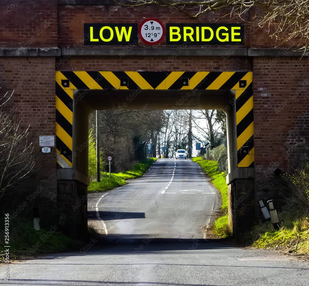The reflective yellow and black warning signs around a railway bridge ...
