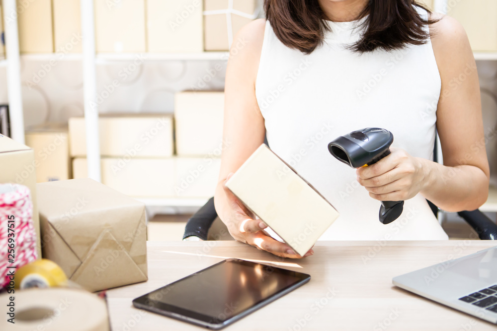 E-commerce concept, young business woman use barcode scanner in hand at ...