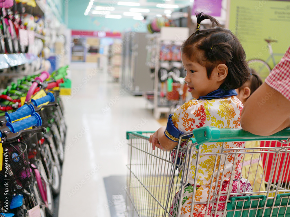 Little Asian baby girl, 38 months old, in a shopping cart, get excited ...