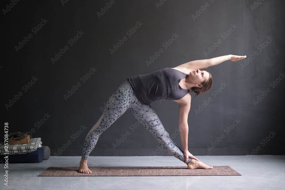 woman practicing yoga, doing Utthita Trikonasana pose Stock Photo ...