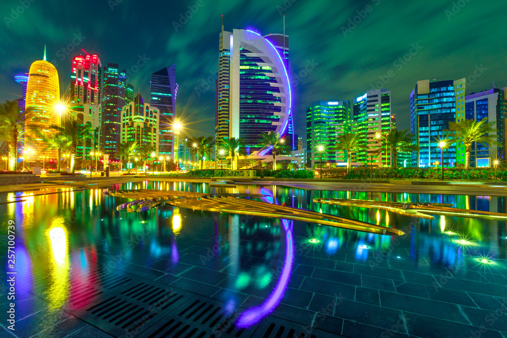 Foto de Doha West Bay high rises illuminated by night reflecting in ...