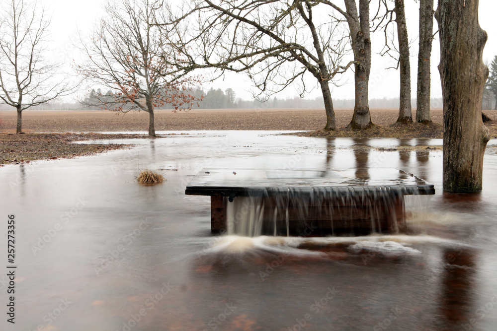 Well with overflowing underground river water in spring. Spring flood ...