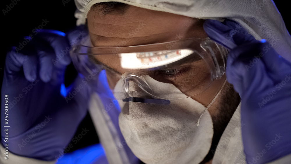 Lab assistant wearing glasses, reflection of test tubes with chemical ...