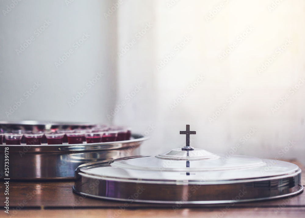 selective focus of the cross on communion tray cover with a wine ...