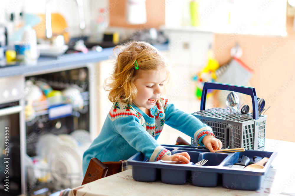 Cute little toddler girl helping in the kitchen with dish washing ...