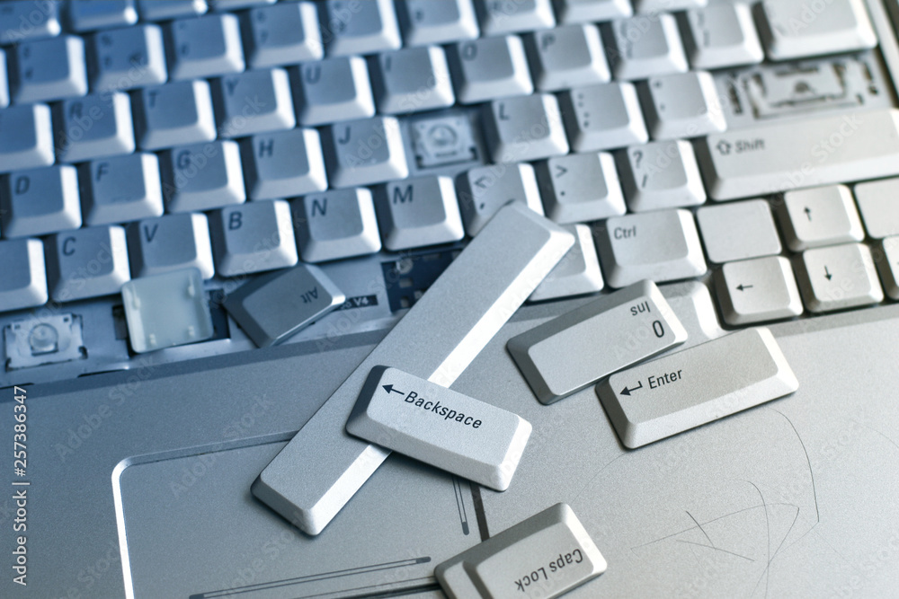 Silver laptop with broken keyboard. A close-up picture of part of ...