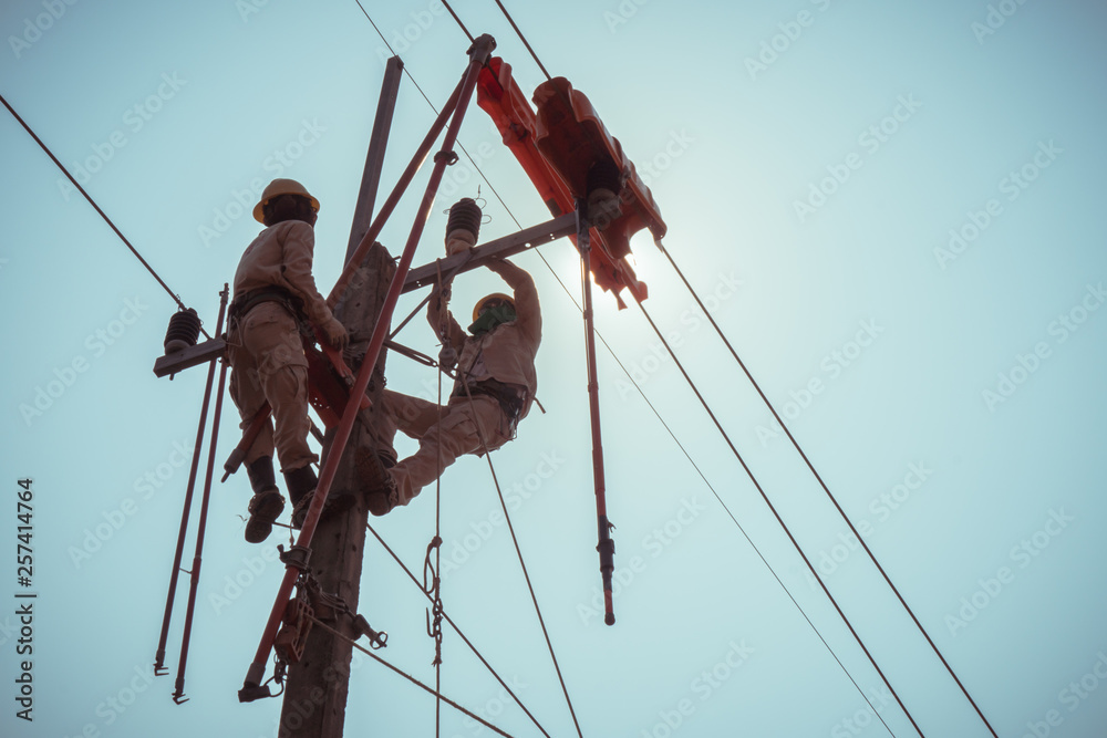 Two linemans use devices that are insulated for maintenance high ...