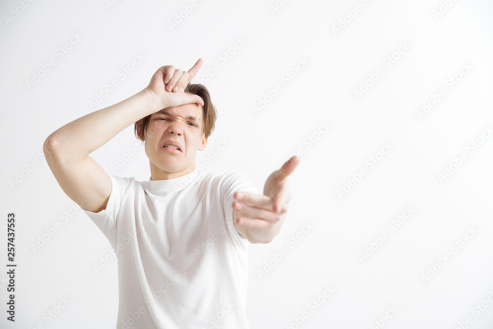 Losers go home. Portrait of happy guy showing loser sign over forehead ...