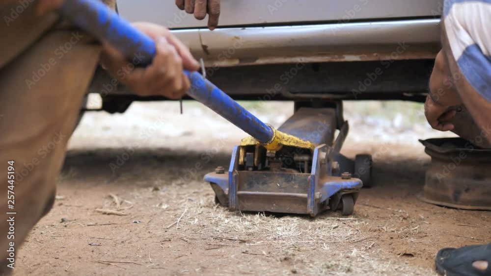 Hands of mechanic using car jack to lift up the truck to repair ...