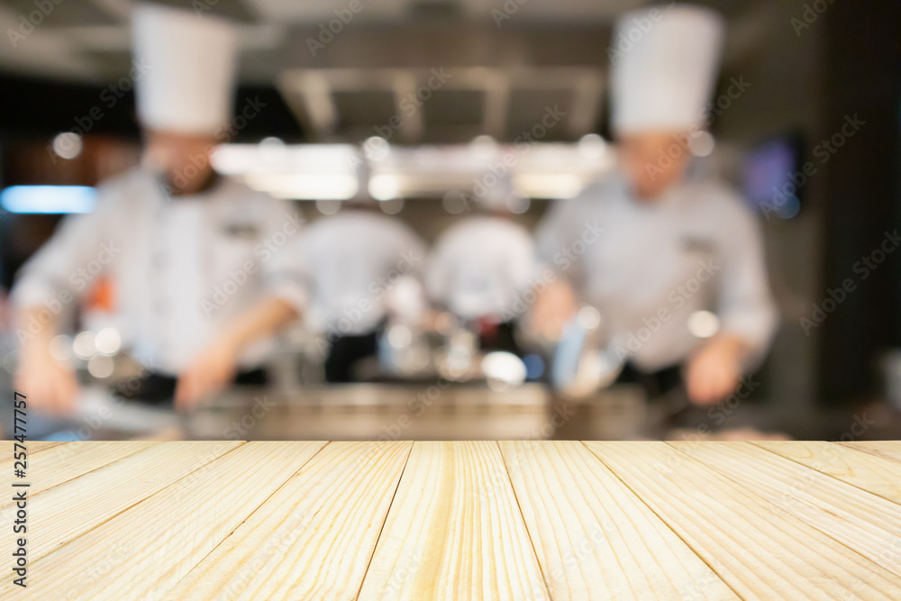 Empty Wood table top with Chef cooking in restaurant kitchen blurred ...