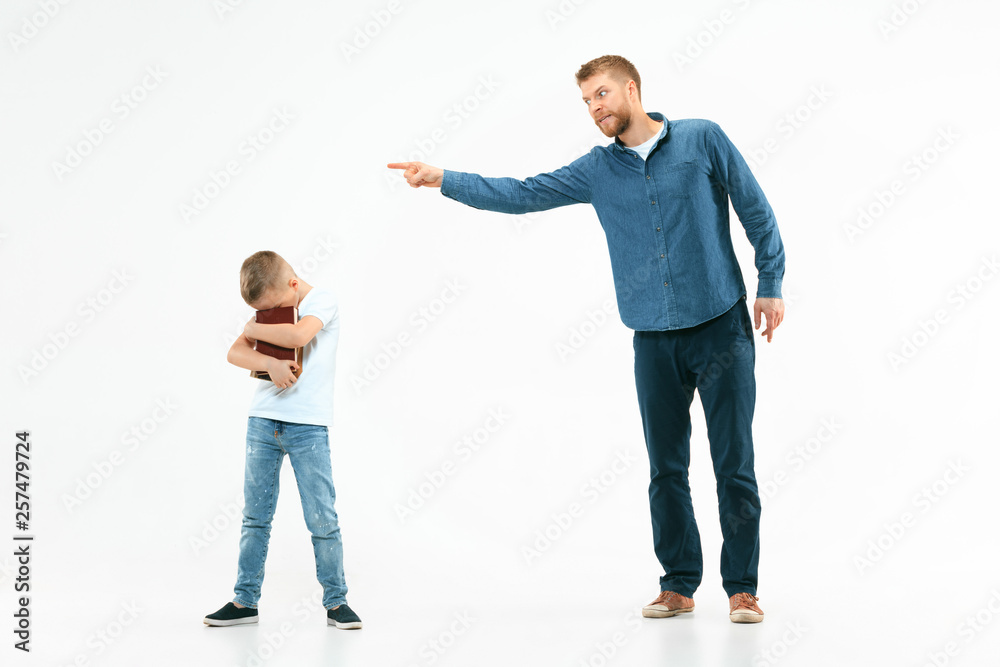 Angry father scolding his son at home. Studio shot of emotional family ...