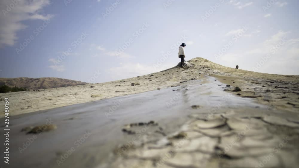 Hardened stream of volcano mud in a lunar landscape. Two children ...