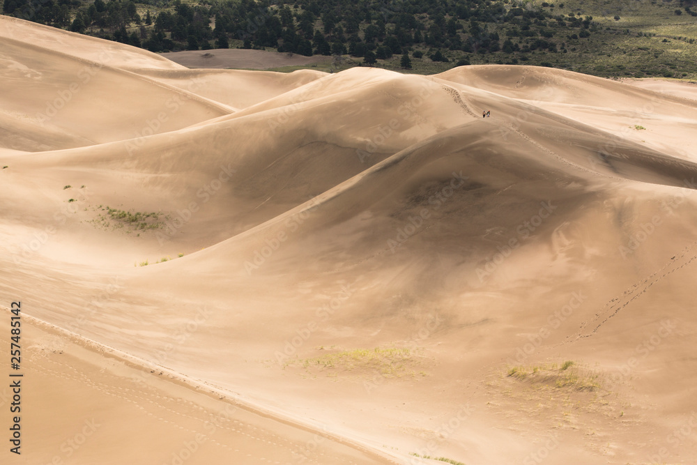Hikers walking on top of giant sand dunes Stock Photo | Adobe Stock
