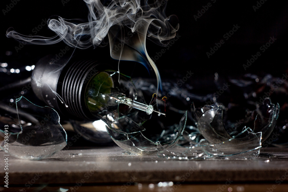 Amazing explosion of burning light bulb with splinters of broken glass ...