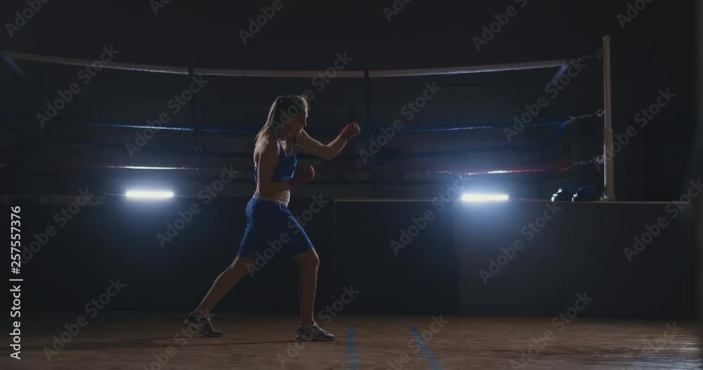 Professional beautiful female boxer shoots off conducting a shadow ...