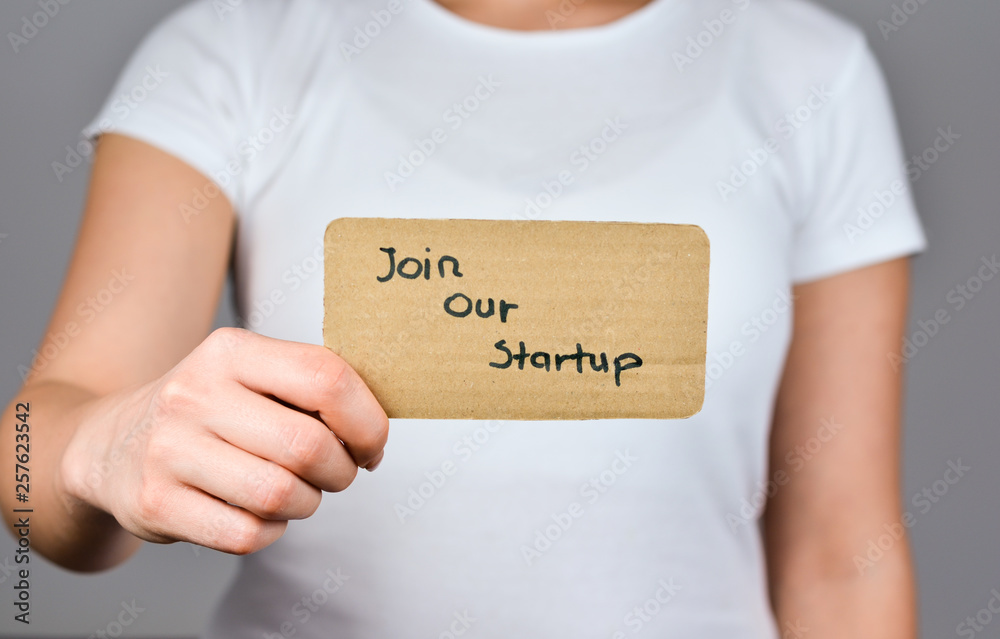 Join our Startup phrase handwritten on square cardboard paper holding ...