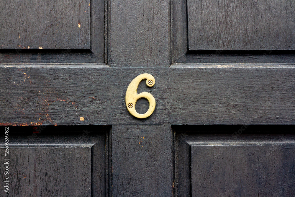 House number six seen with the 6 in bronze on the black crossbar of a ...