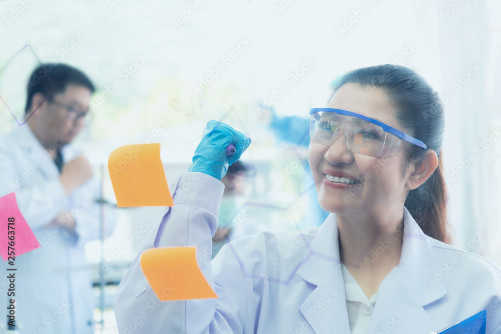 Team work Scientists analyzing study data and evaluating microscope ...