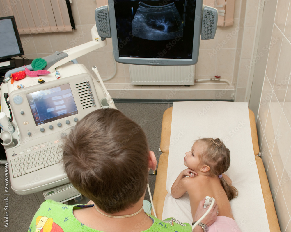 Medical exam of a little girl by ultrasound equipment. Doctor and ...