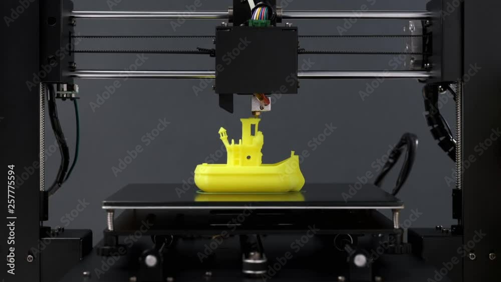 Printing on 3D printer figurines ship yellow plastic close-up. Clear ...