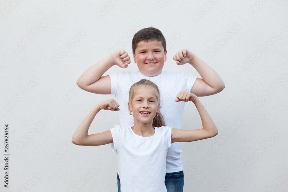 thin happy smiling little girl and thick fat caucasian boy showing ...