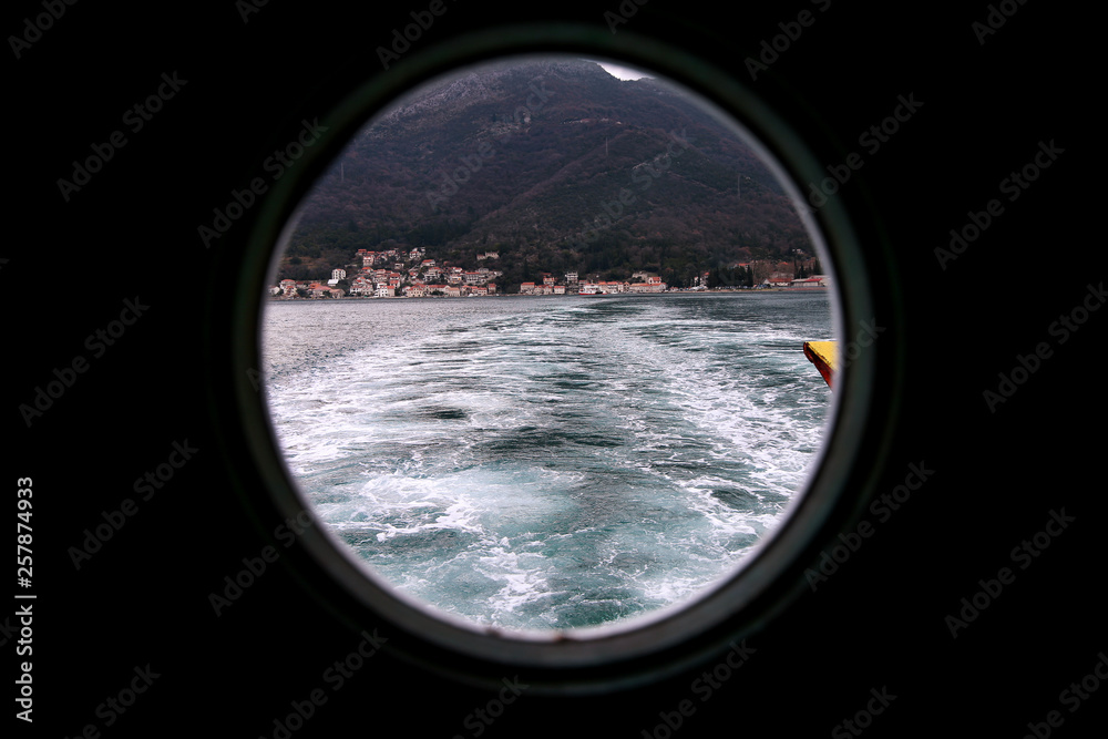 Hinged round window, storm cover on ship looking outside into ...