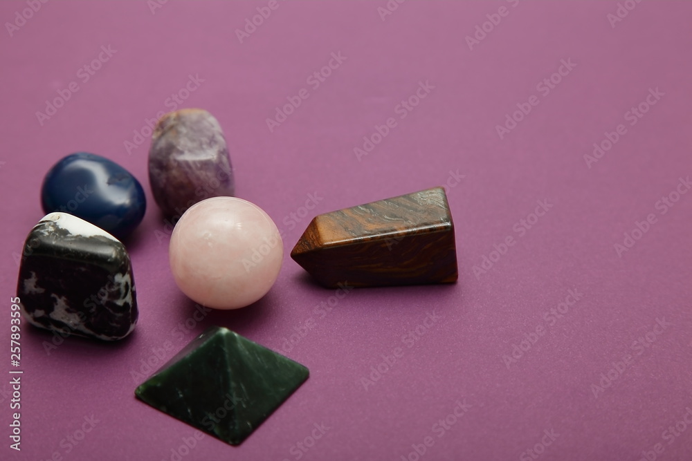 Magic stones and crystals of different shapes and colors lying in bulk ...