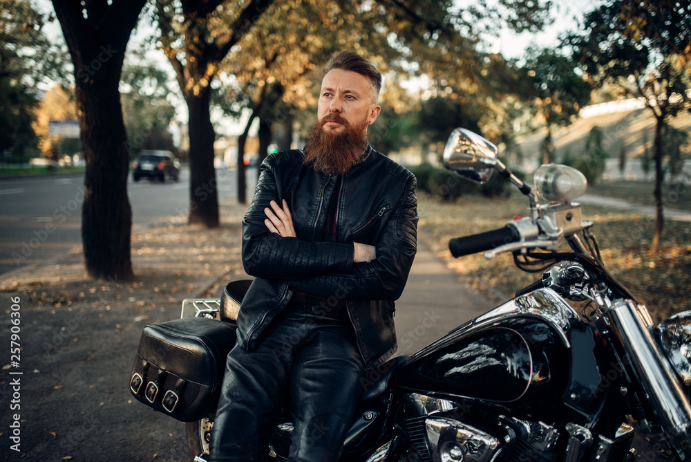 Biker in leather jacket poses with his chopper Stock Photo | Adobe Stock