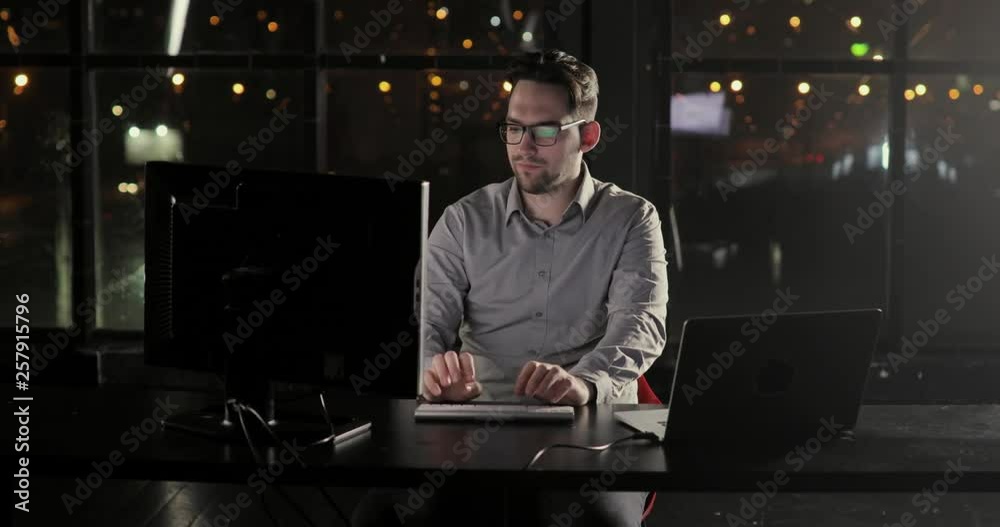 Vidéo Stock Young hacker programmer man in glasses is working in the ...
