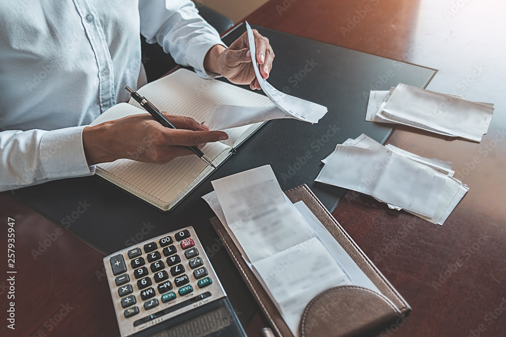 Woman with bills and calculator. Woman using calculator to calculate ...