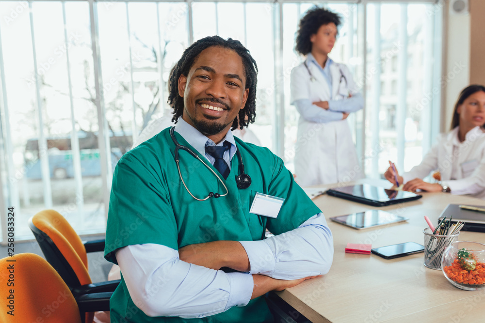 Handsome african american medical doctor with colleagues in background ...