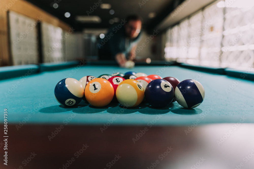Colorful billiard balls on a table with green mat. The balls are placed ...