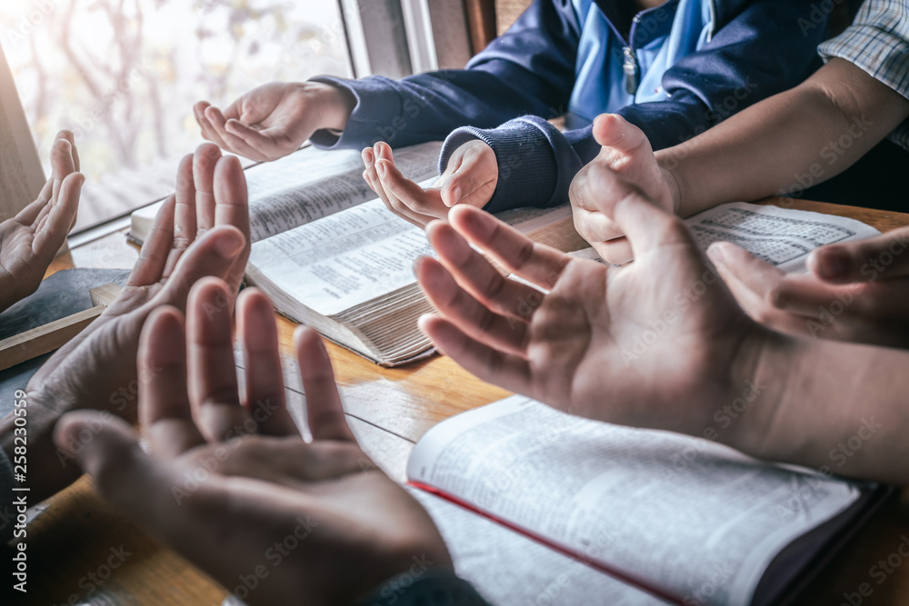Christian children group praying together around wooden table with open ...