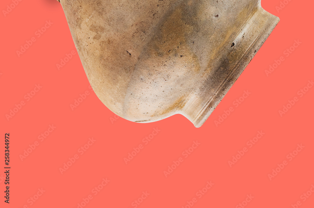 One old antique worn and dirty vase on coral color table with copy ...