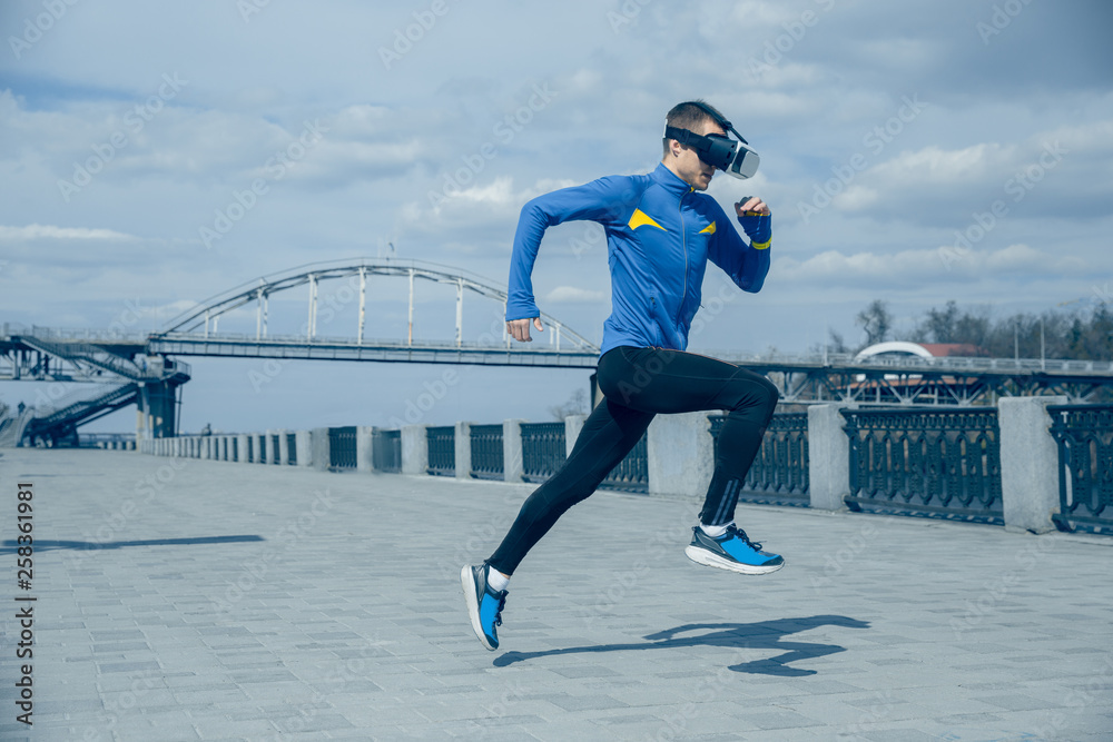 Man running on city background. Handsome athlete using VR glasses while ...