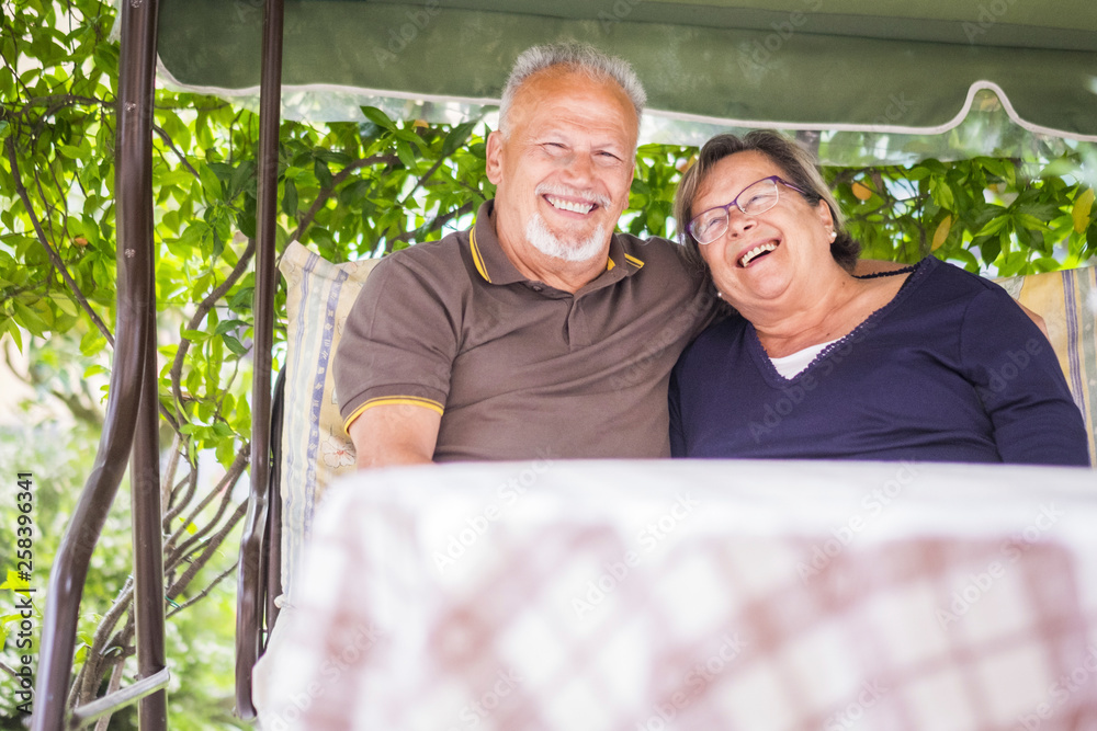 nice couple of beautiful caucasian senior 70 years old sit outdoor at ...