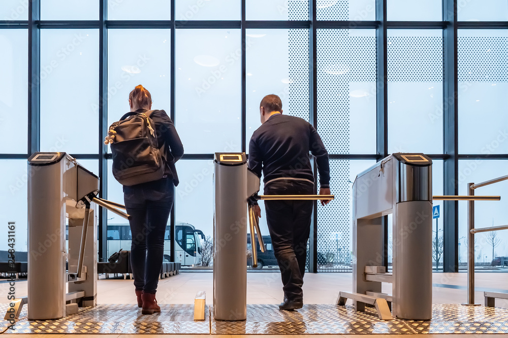 People pass through the checkpoint. Turnstile. Visiting control. Metal ...