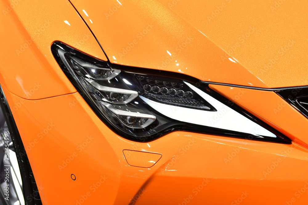 Detail on one of the LED headlights orange car. Stock Photo | Adobe Stock