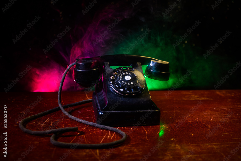 old black telephone on old wood plank with art dark background with fog ...
