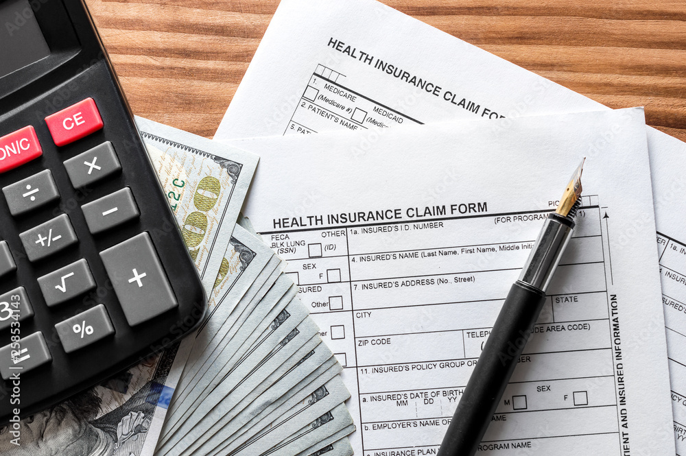 Health insurance claim form with calculator, money and pen on the table ...