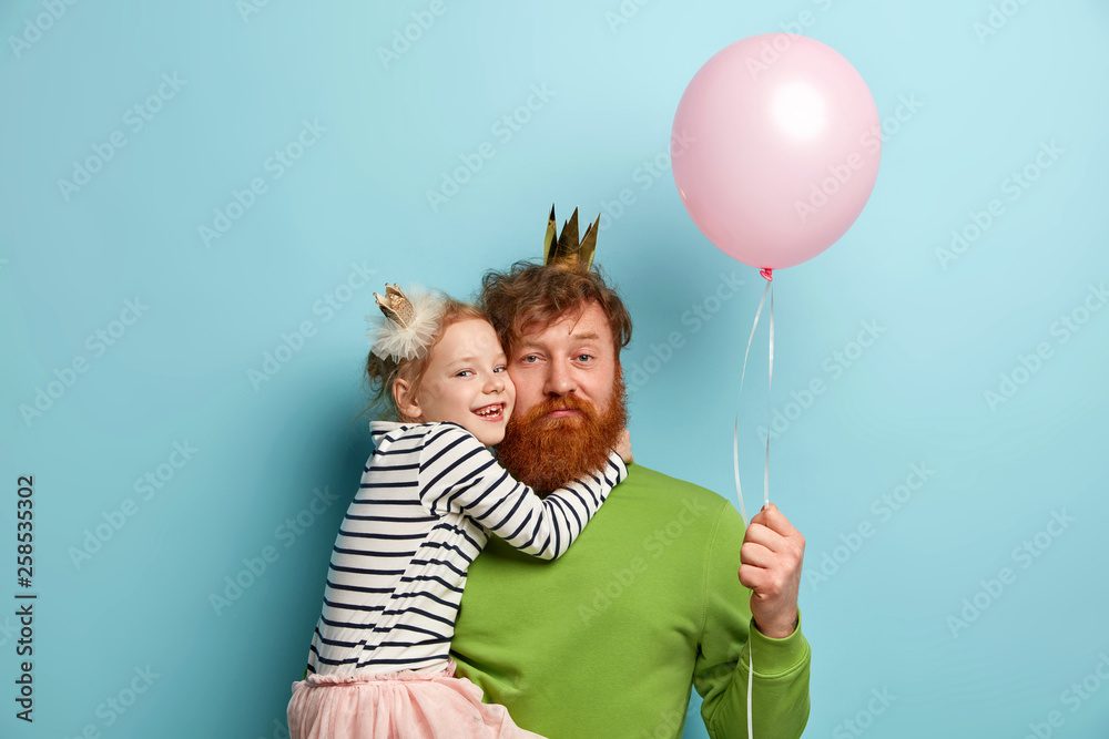 Fancy party concept. Lovely cheerful little kid embraces affectionately ...